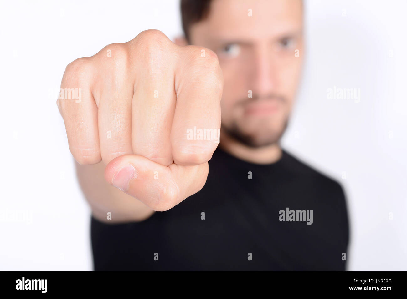 Portrait of a young man punching to the front. Isolated white ...