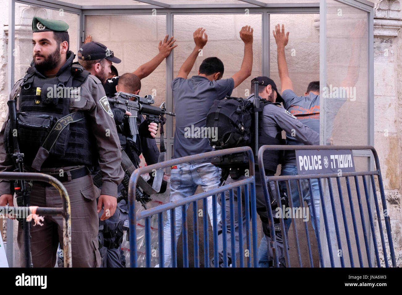 Members of the Israeli Security Forces perform a body search on ...