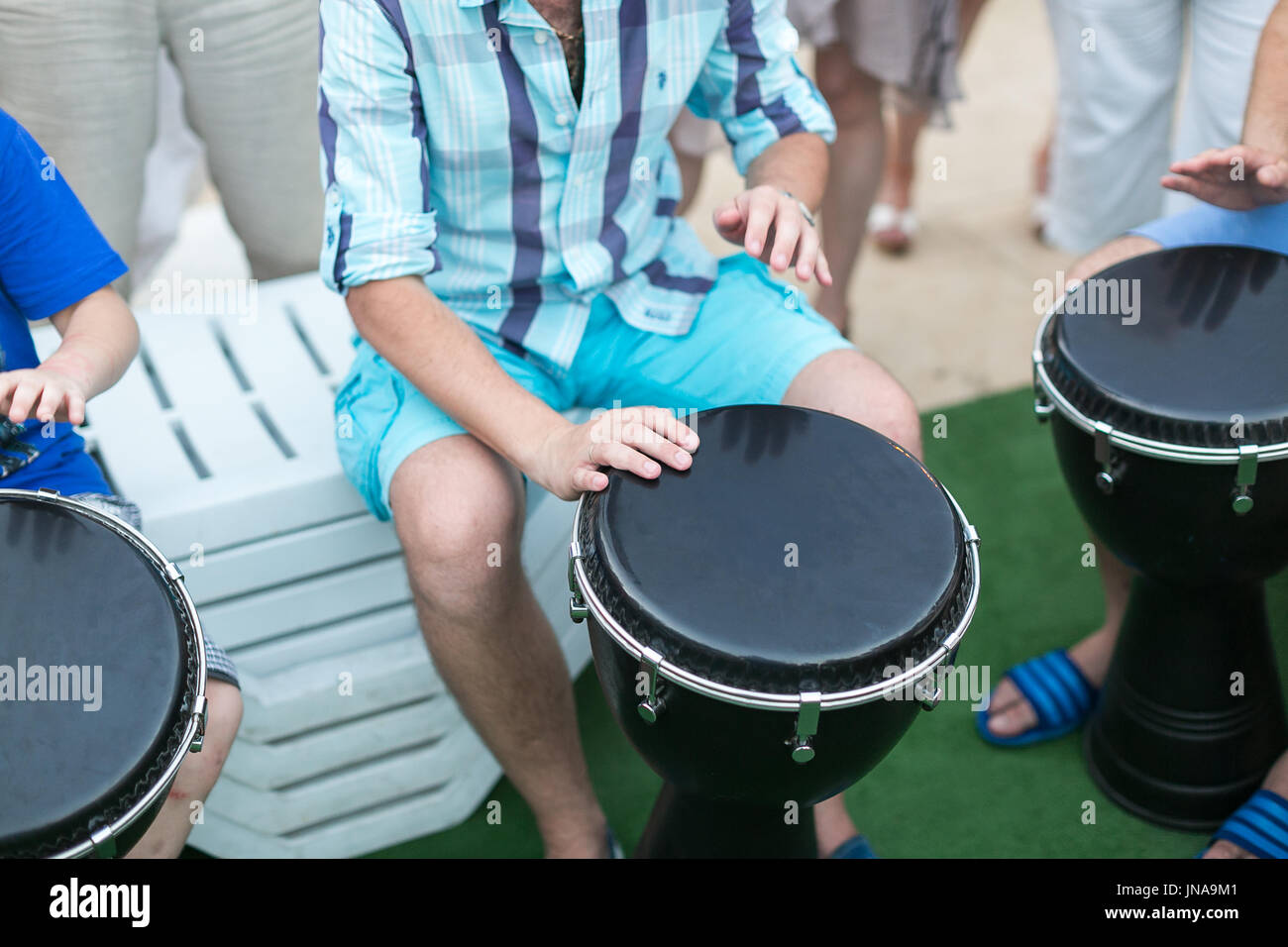 drum, percussion instruments and culture concept - closeup on hands of ...