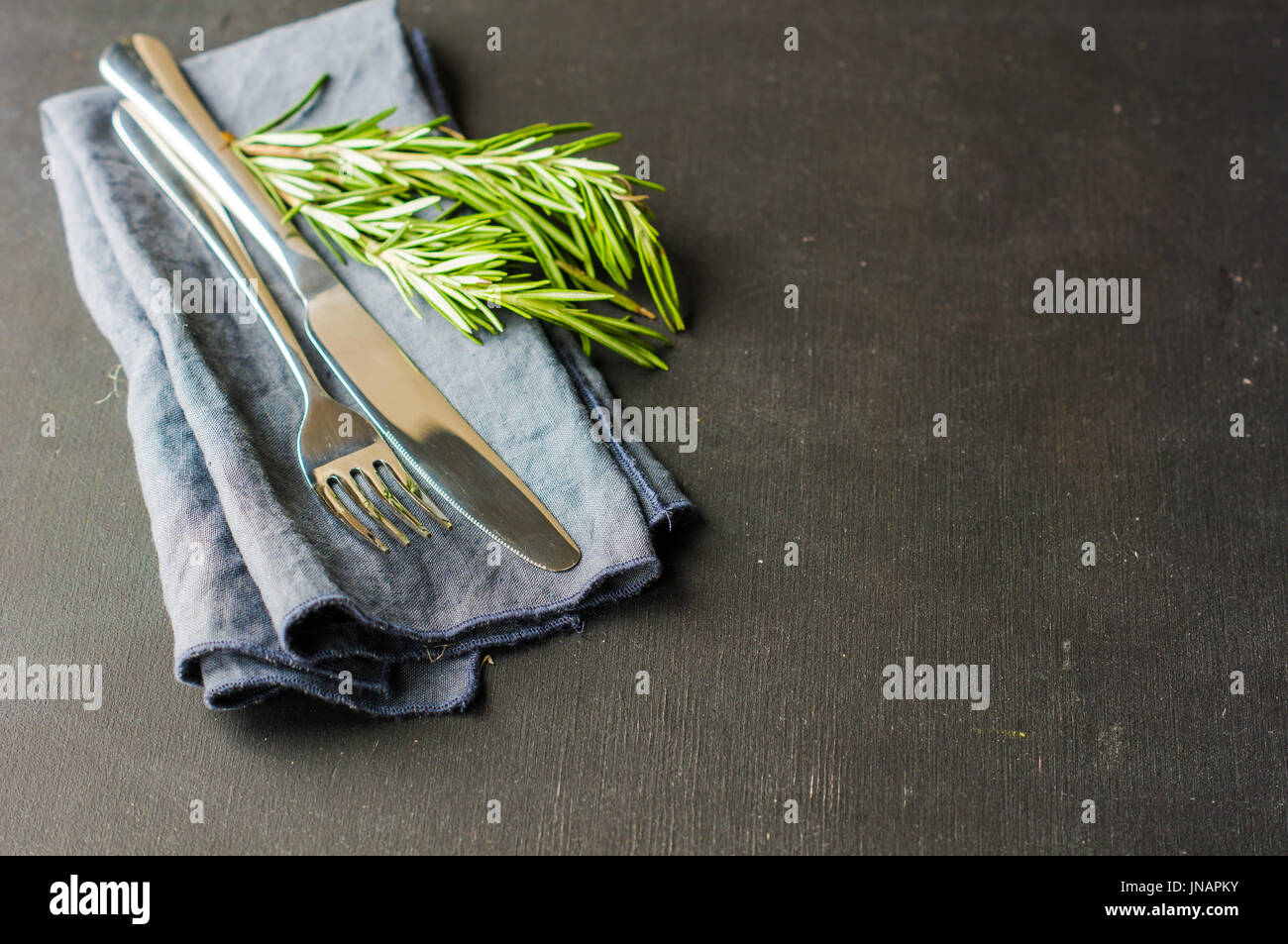 Rustic table setting with rosemary on dark wooden table with copyspace ...