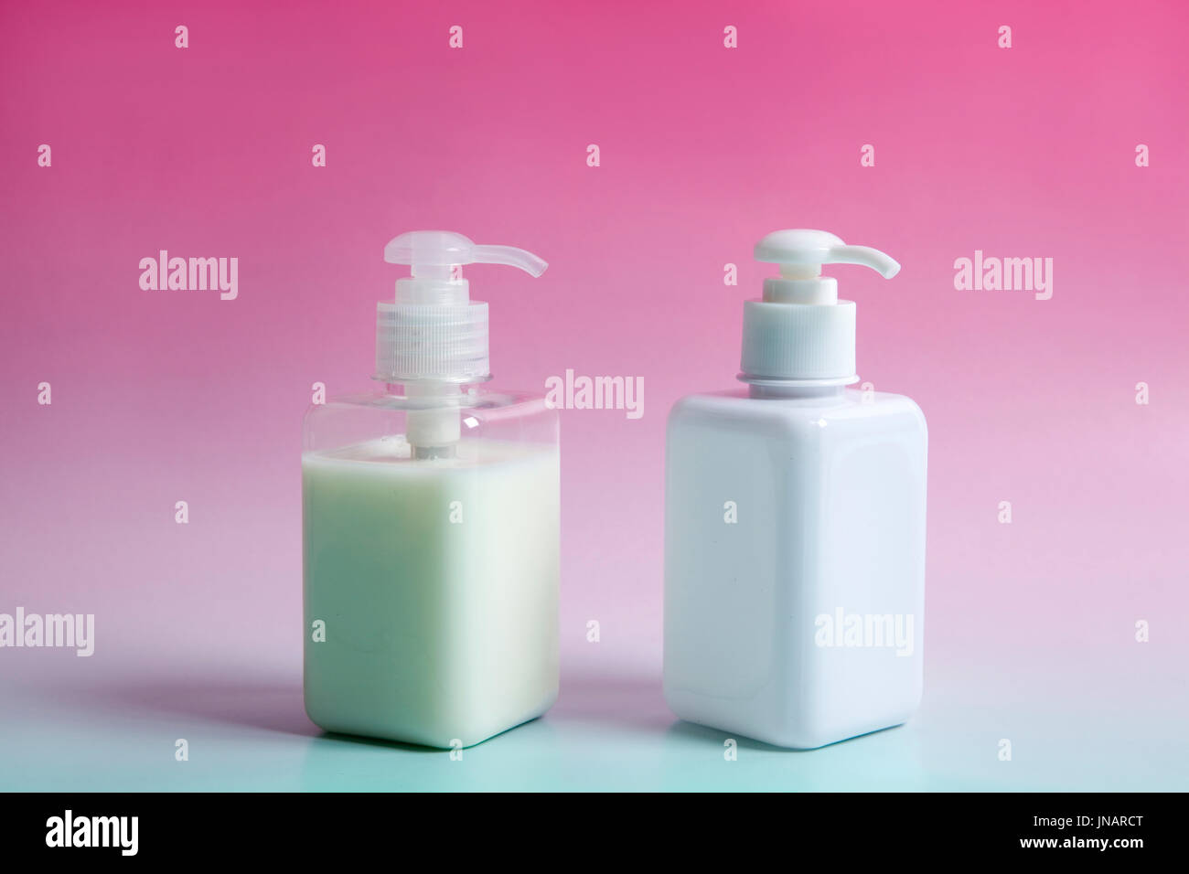 two rectangular pump bottles : white and transparent, on a gradient ...