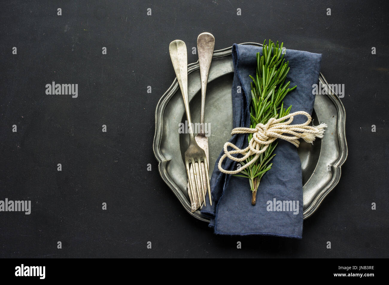Rustic table setting with rosemary on dark wooden table with copyspace ...
