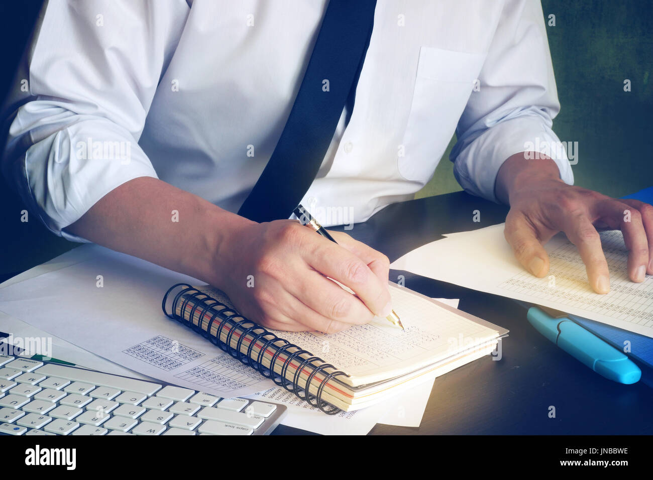 Businessman writing financial data into accounting book Stock Photo - Alamy