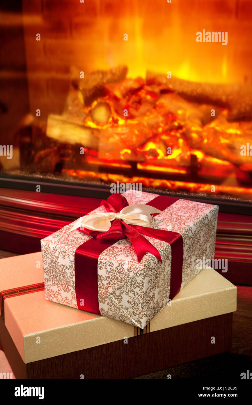 Christmas gift boxes with red ribbon in the interior with a fireplace ...
