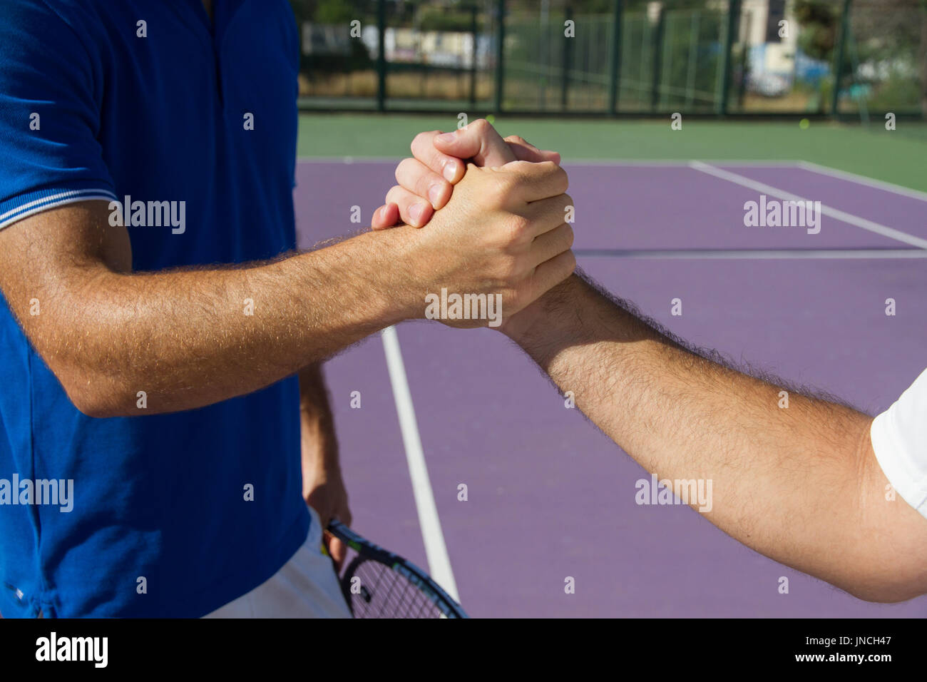 Two men, professional tennis players shake hands before and after the ...