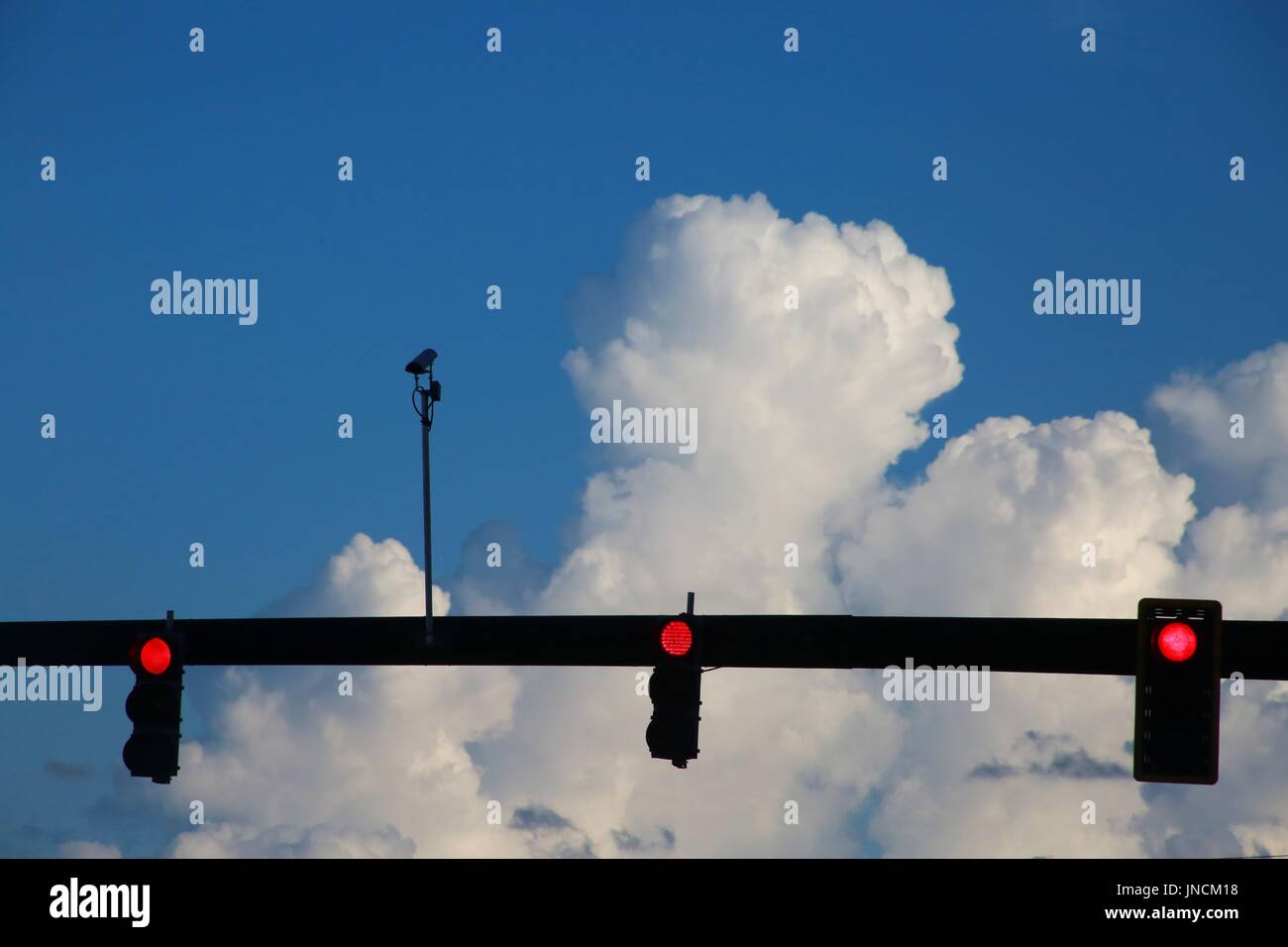 Three Red Traffic Lights with Camera on Post Above at Intersection ...