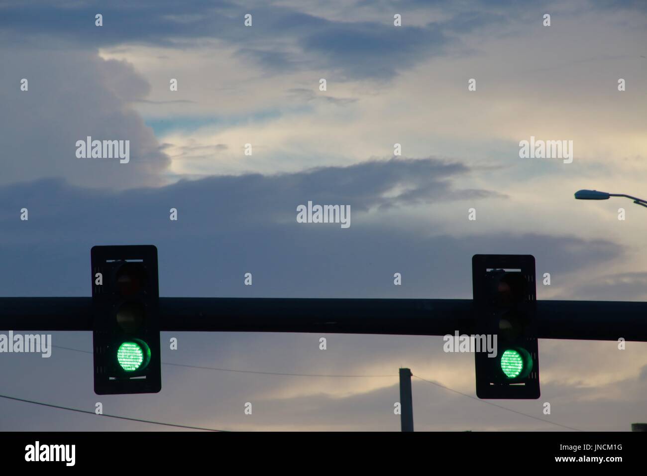 Two Green Illuminated Traffic Lights at Intersection Beneath Blue Gray ...