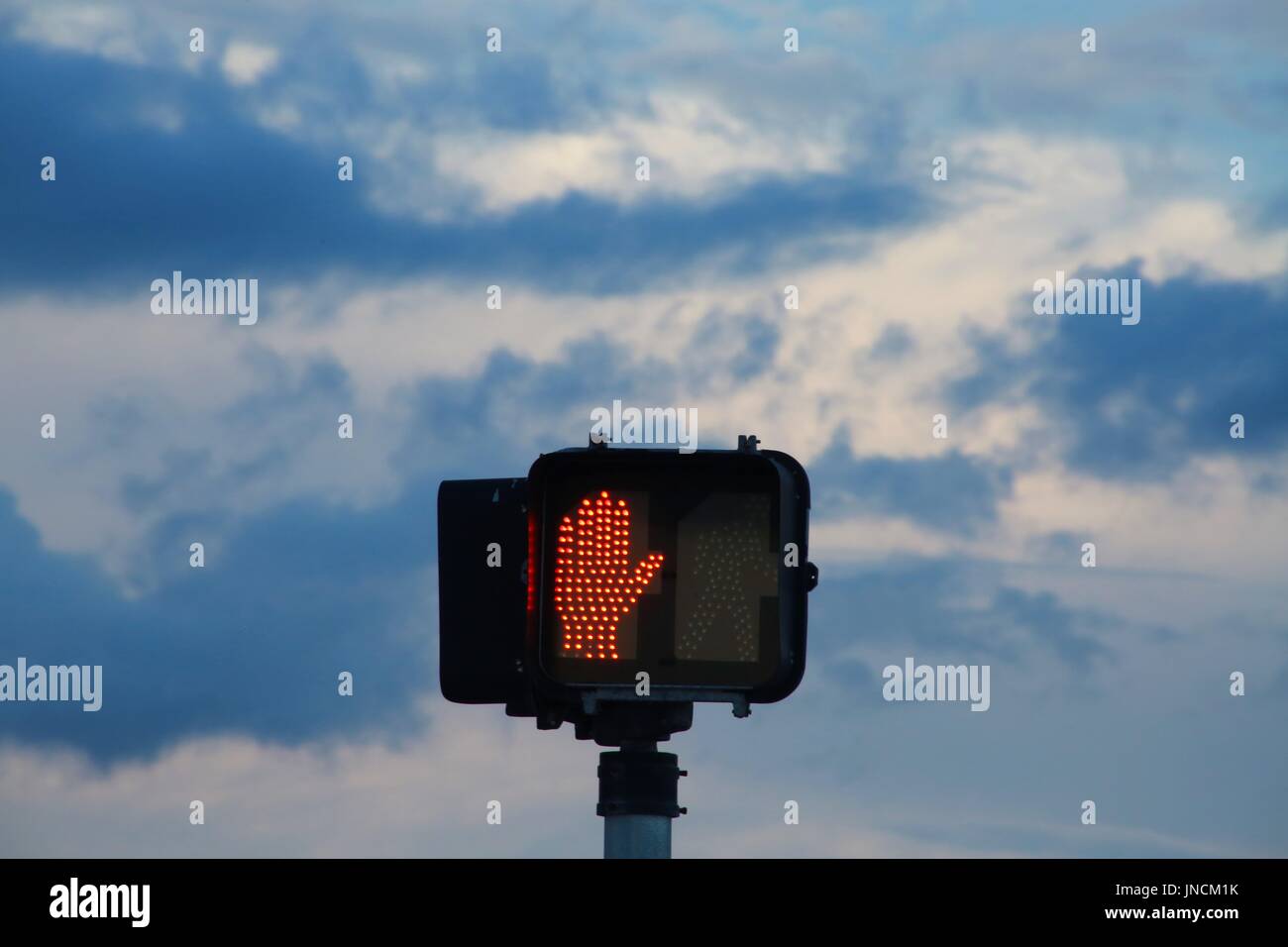 Red Illuminated Don't Walk Hand Up Signal Symbol at Intersection at ...