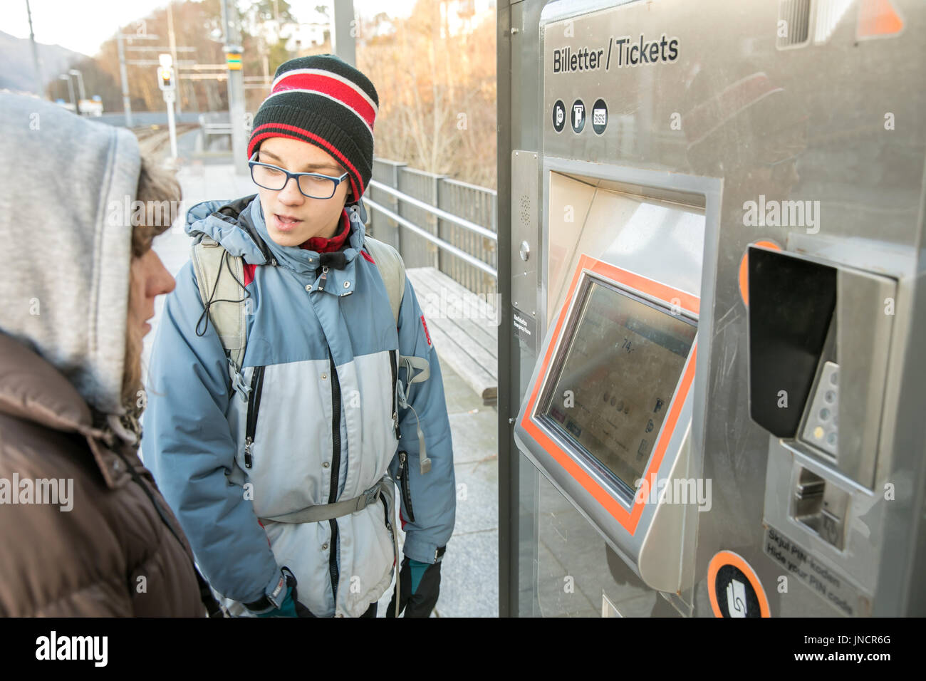 Boy and woman buy tickets at the ticket booth at the tram stop in ...