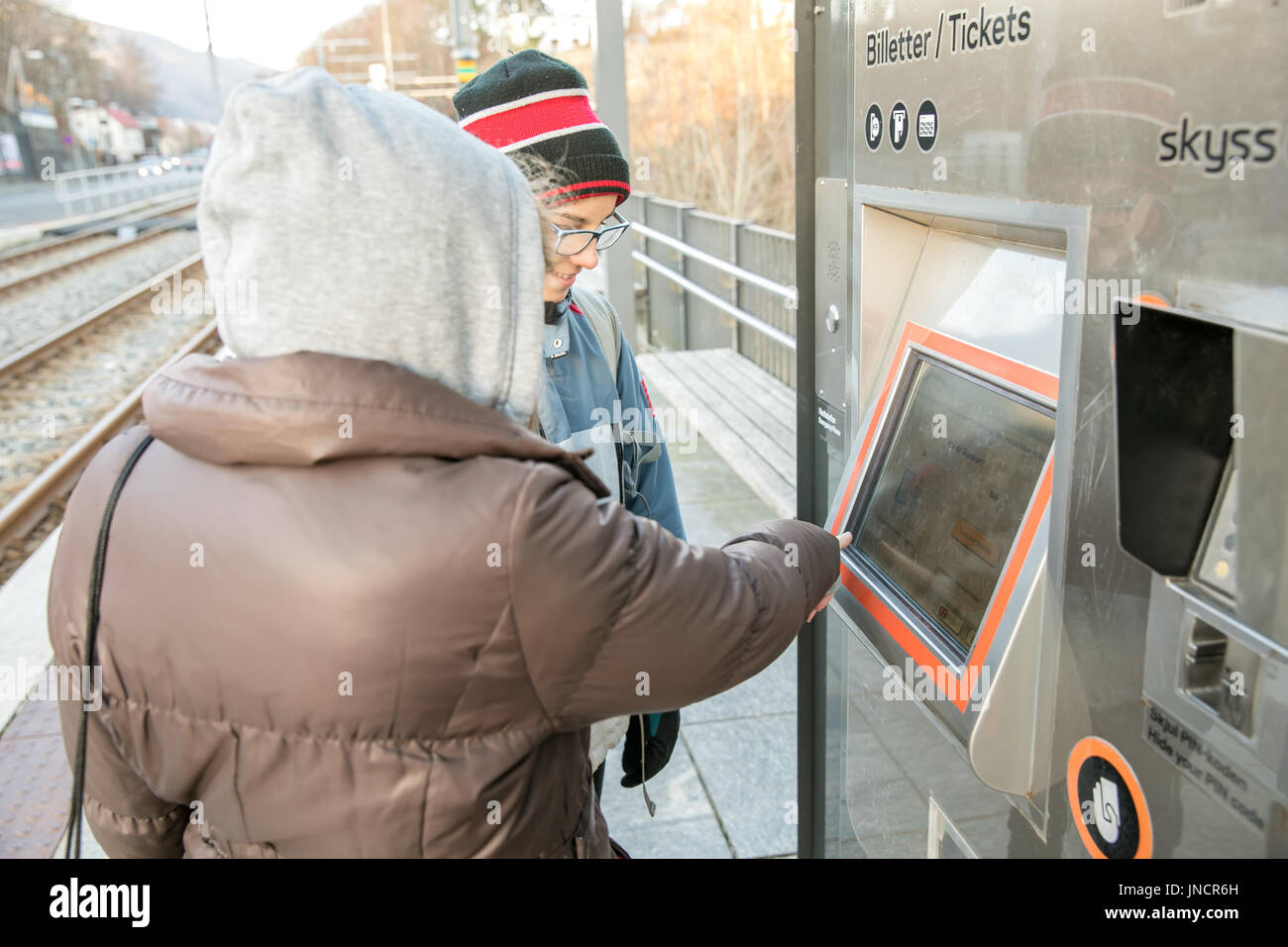 Boy and woman buy tickets at the ticket booth at the tram stop in ...