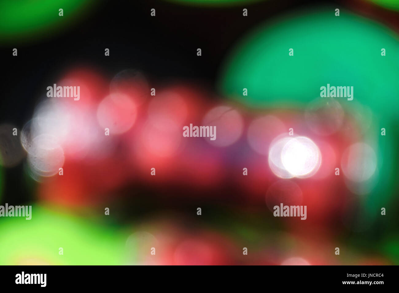 Blurred image, bright red spots against green and black background ...