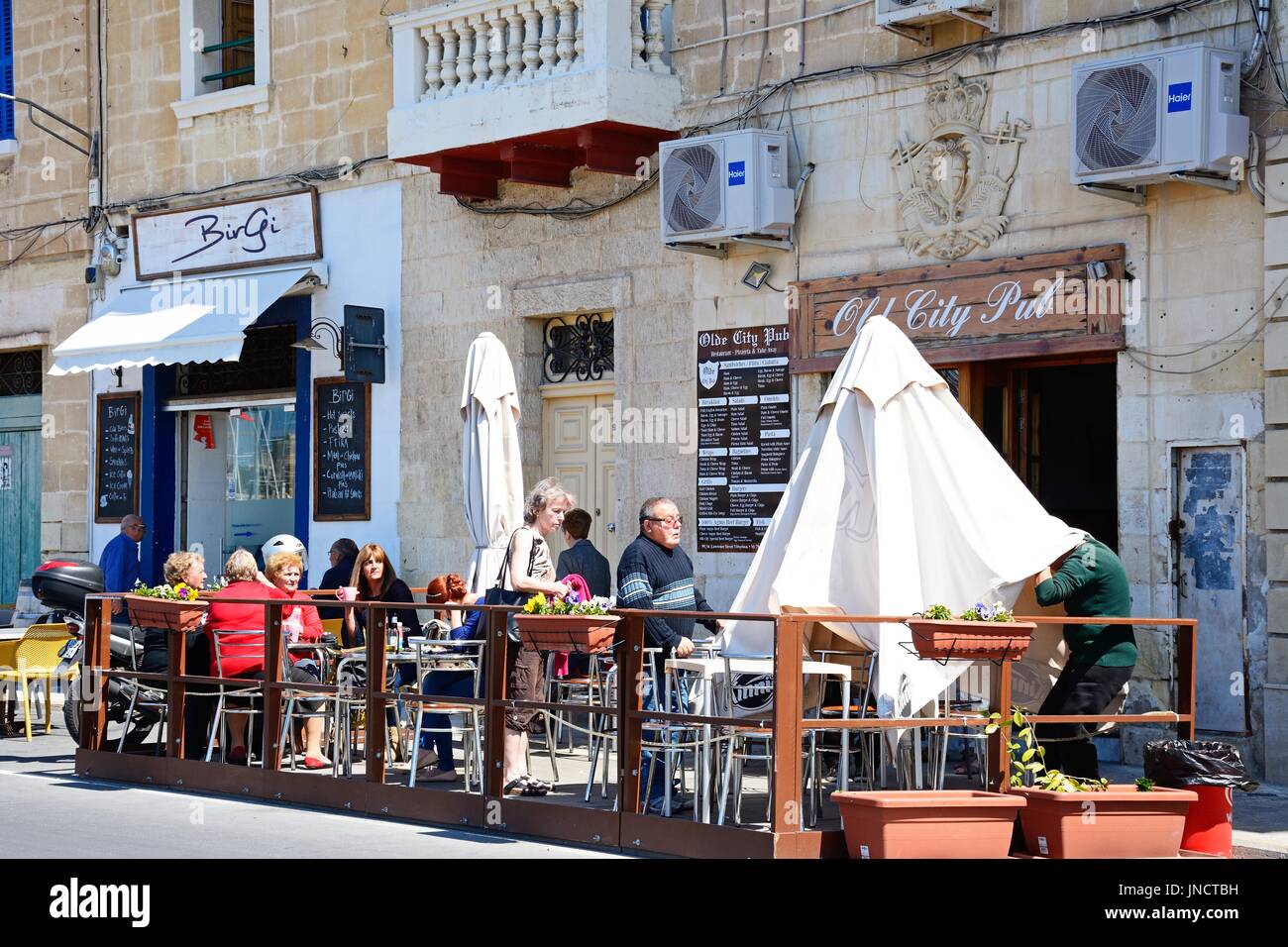 Tourists relaxing at a pavement cafe along the waterfront, Vittoriosa ...