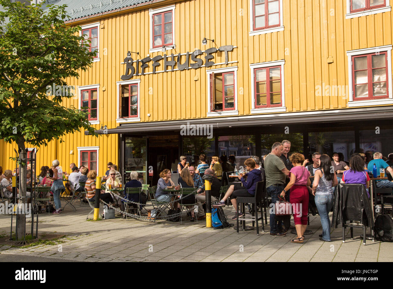 Biffhuset pub with people drinking in summer sunshine outdoors, Tromso ...