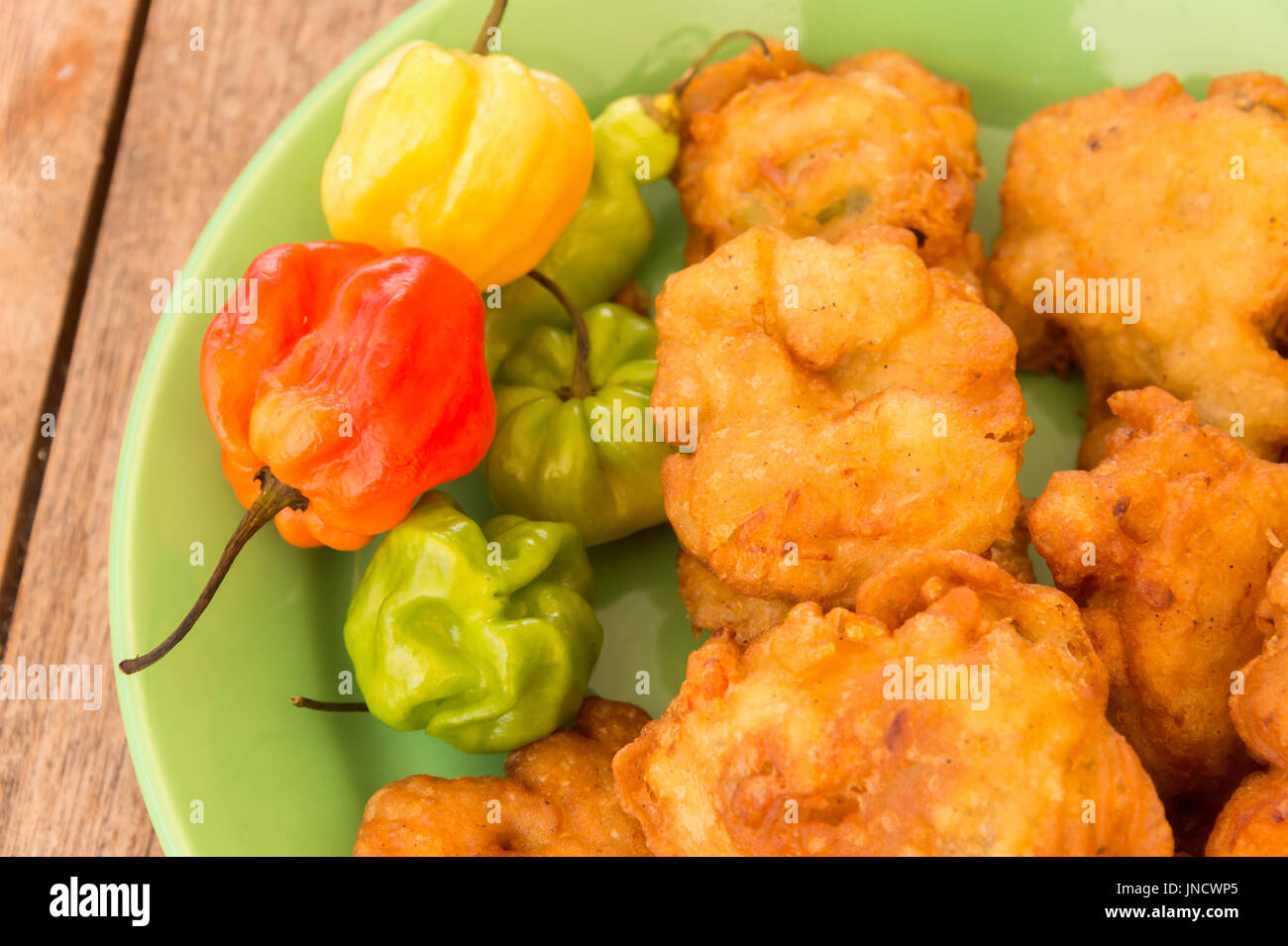 Salt cod fritters (accras de morue) on a plate with habanero peppers in ...