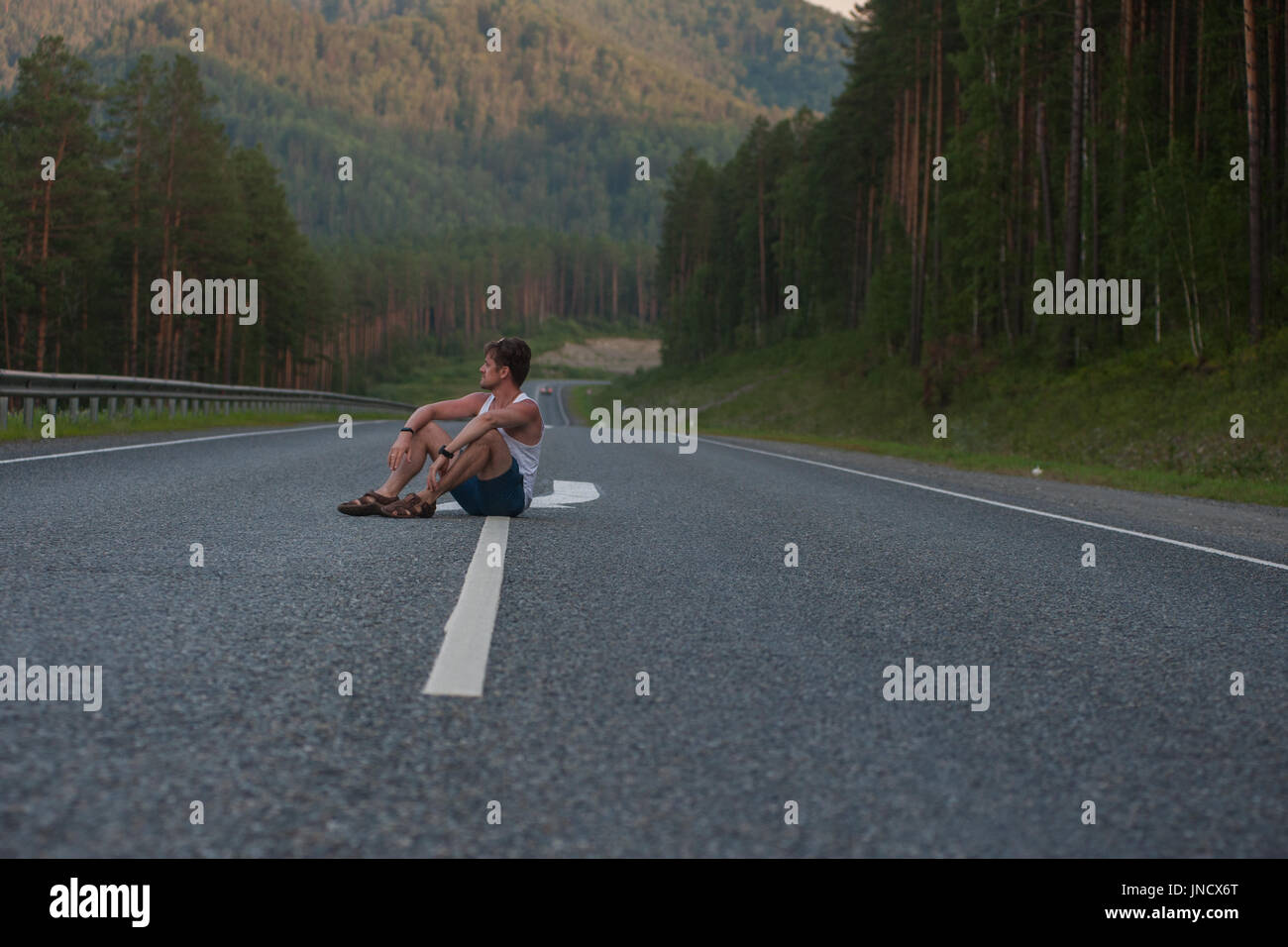 Man sitting on the road Stock Photo - Alamy