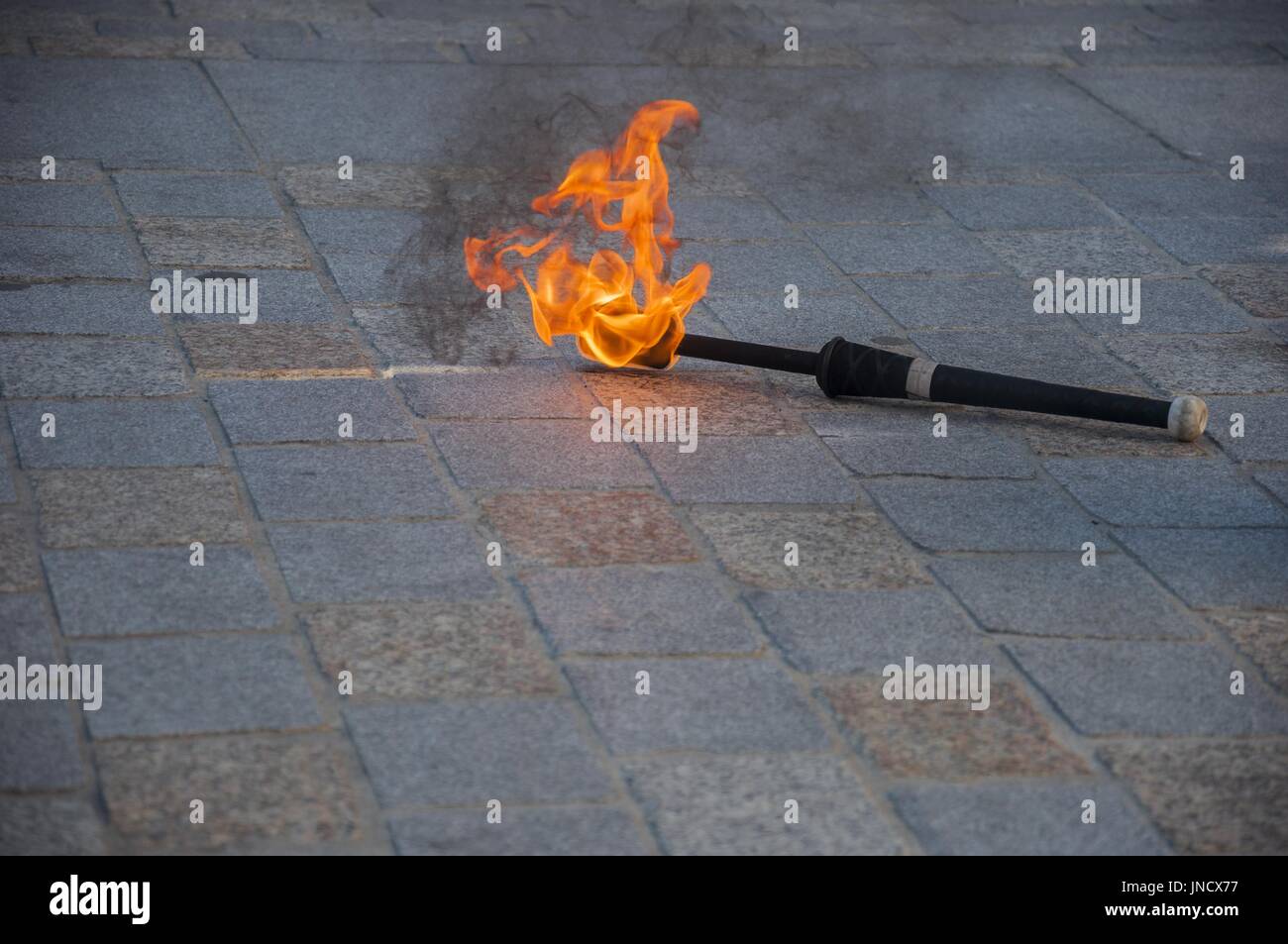a firing torch lying on the brick sidewalk Stock Photo - Alamy