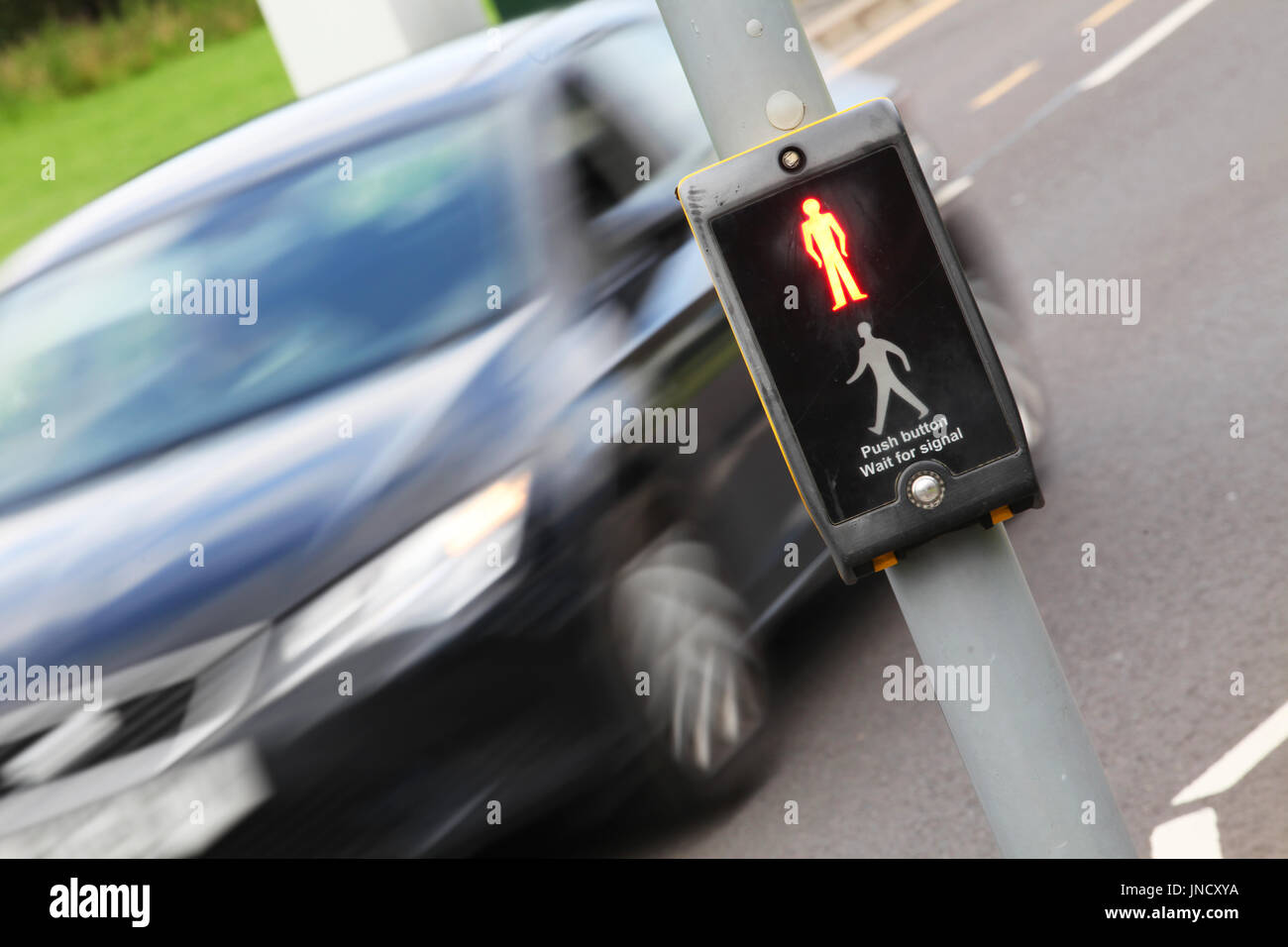 a car passes through a pedestrian crossing showing the red man ...