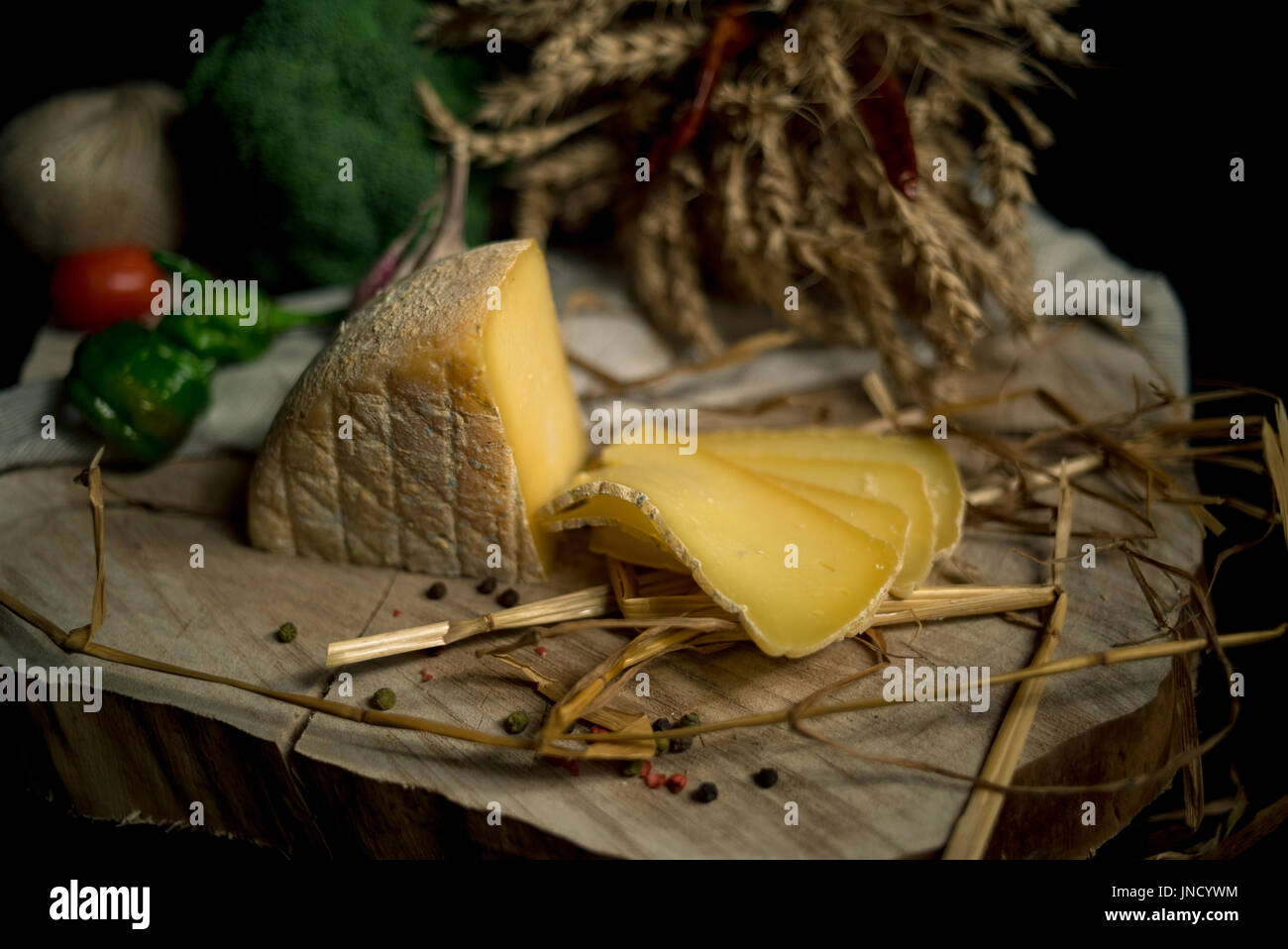 Sliced handmade cheese on a wood board and black background Stock Photo ...