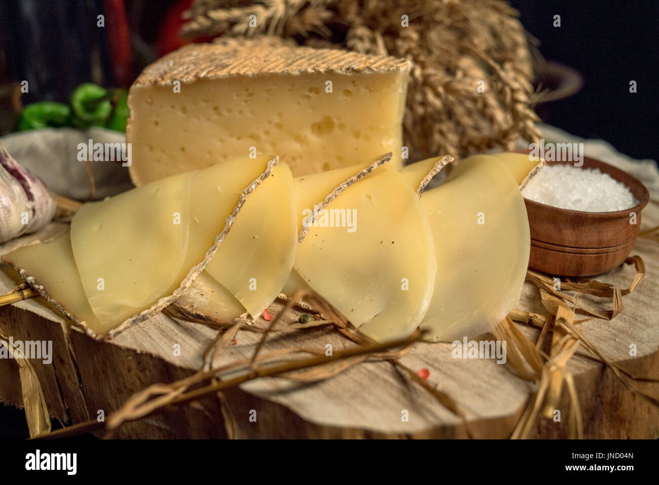 Sliced handmade cheese on a wood board and black background Stock Photo ...
