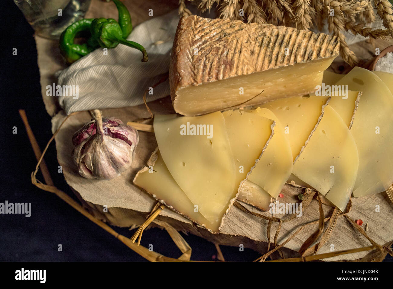 Sliced handmade cheese on a wood board and black background Stock Photo ...