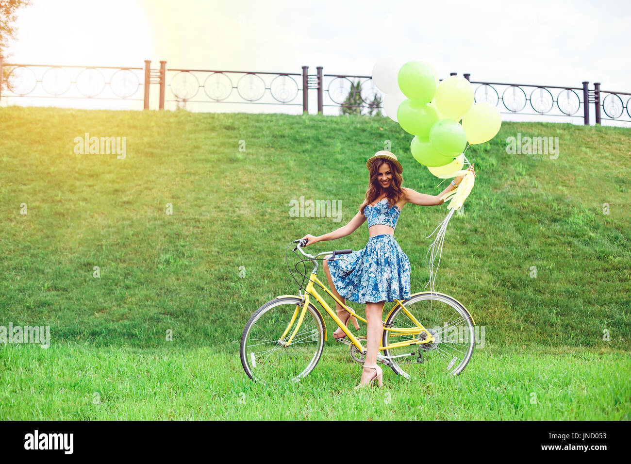 Outdoor fashion portrait of elegant lady riding her hipster retro bike ...