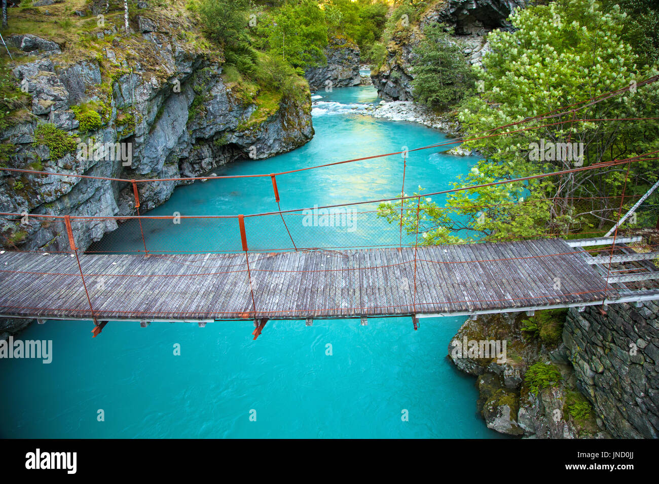 small rope bridge over green Utla river in Utladalen, Norway Stock ...