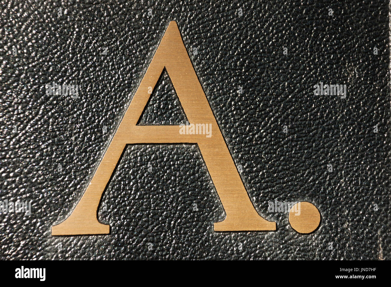 Gold iInitial A. on section of black textured sign Stock Photo - Alamy