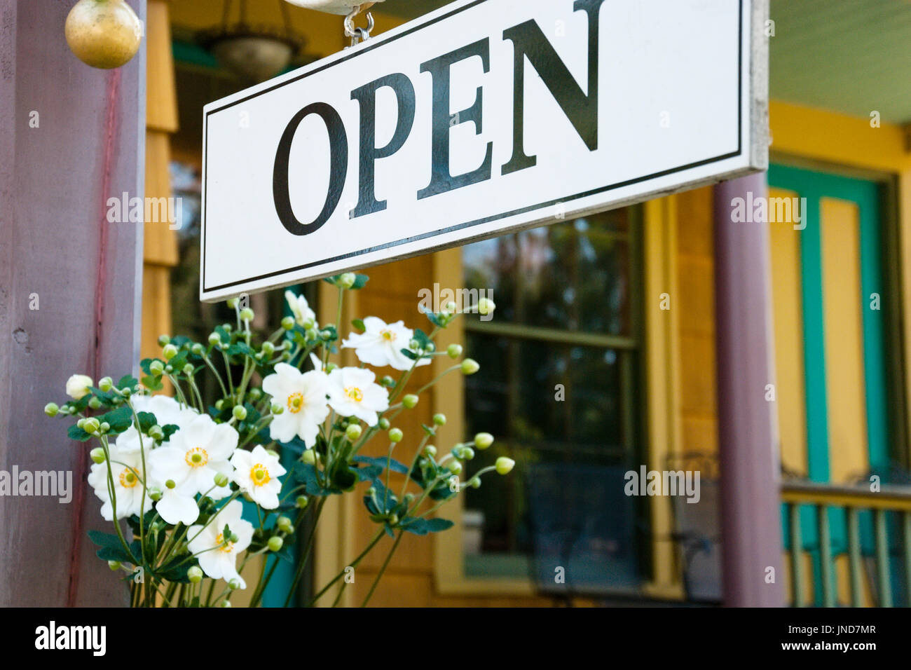 Open sign displayed on colorful cafe amid flowers Stock Photo - Alamy