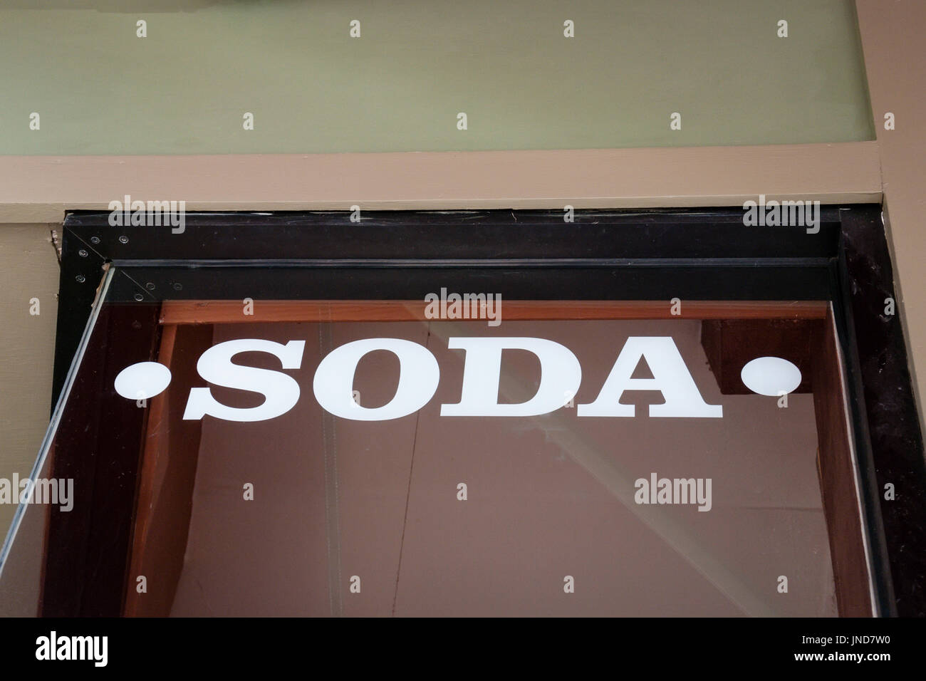 The word SODA stenciled in white on glass window Stock Photo - Alamy