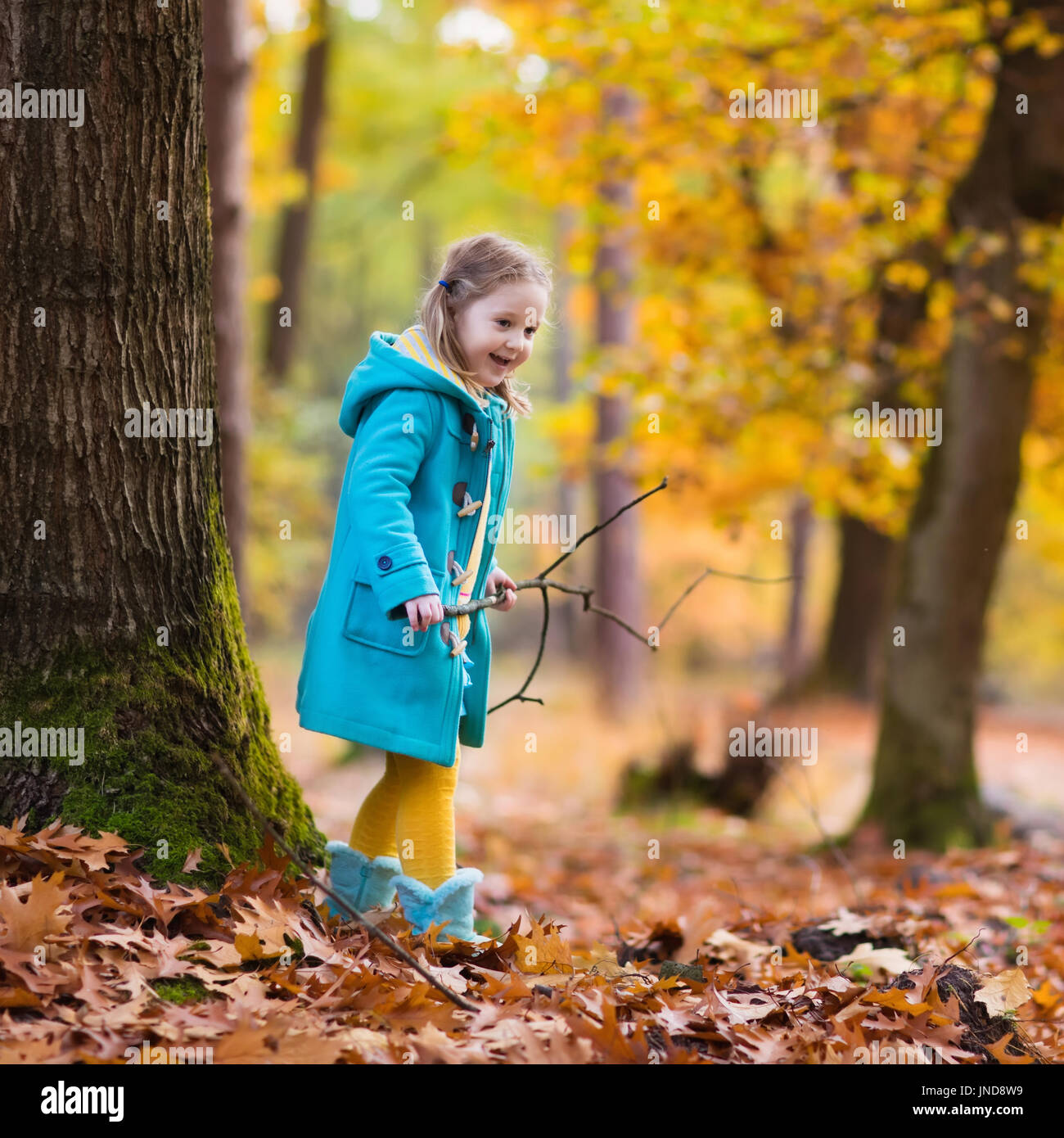 Kids play in autumn park. Children throwing yellow and red leaves ...
