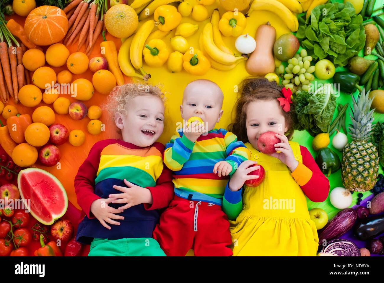 Boy, girl and baby with variety of fruit and vegetable. Colorful ...