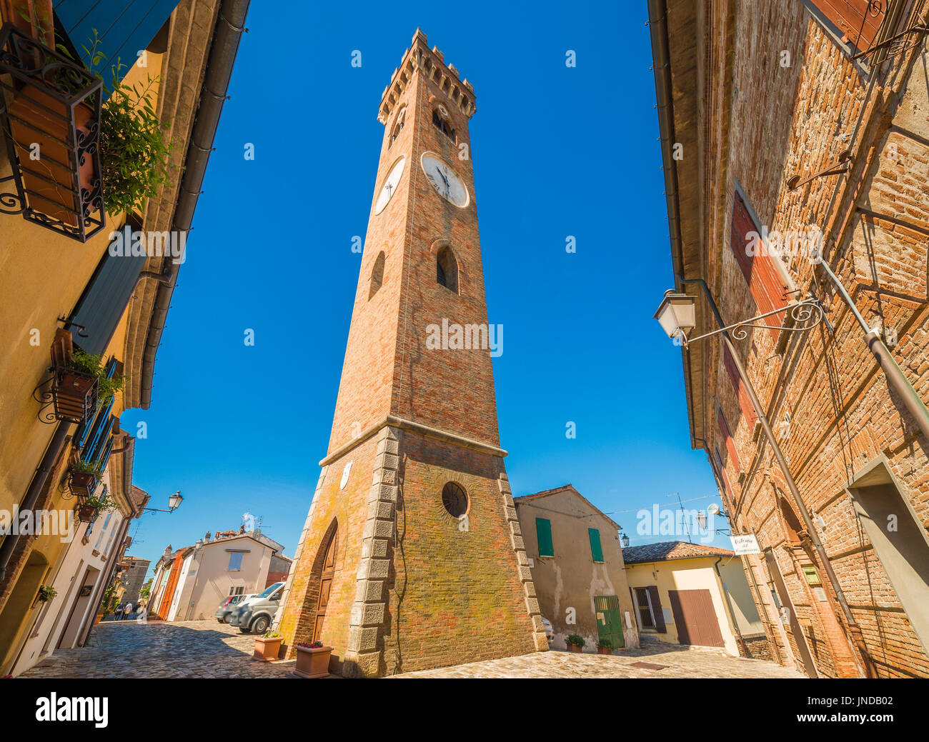dizzy clock tower in ancient square of medieval village in Romagna ...