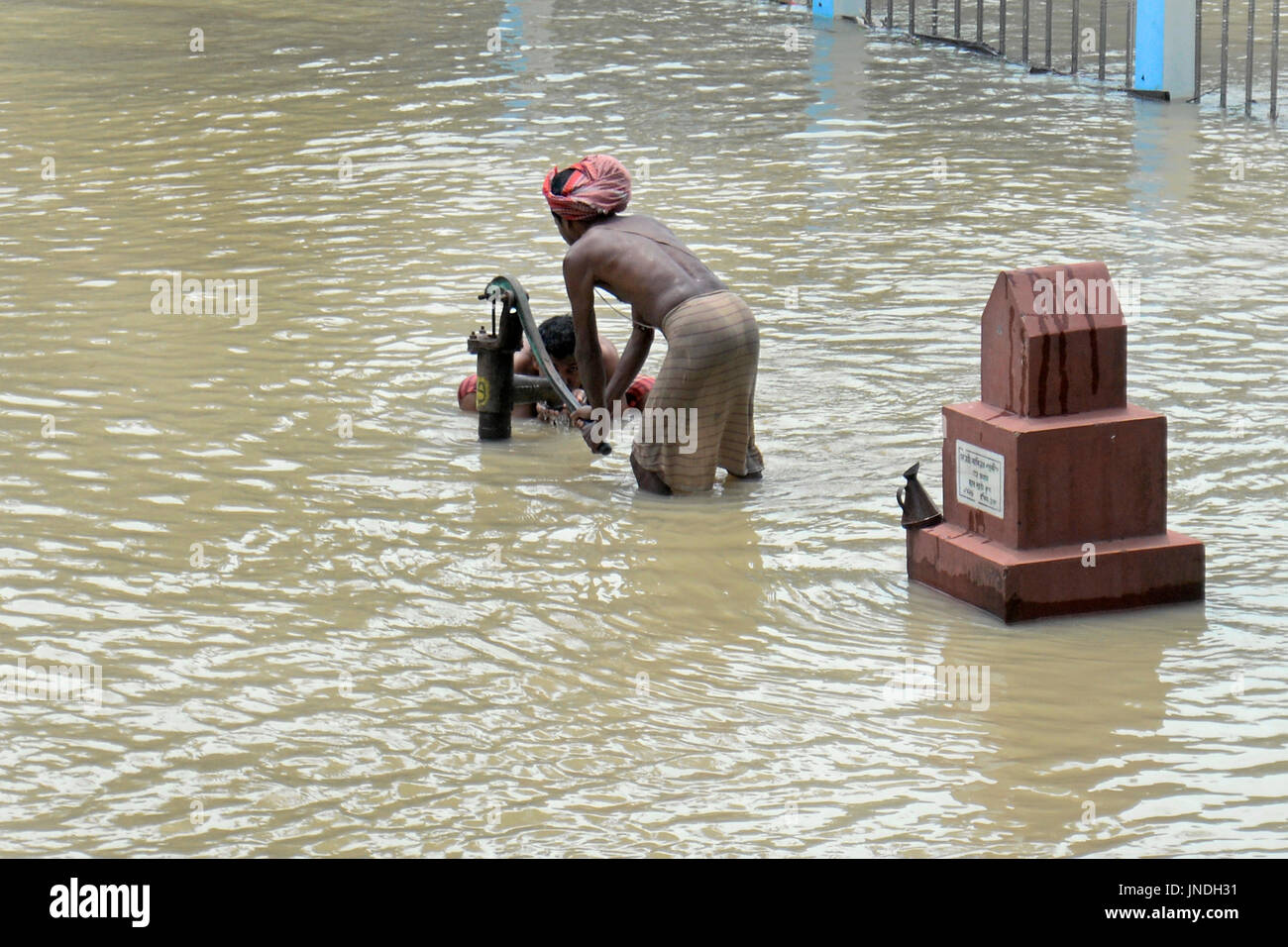 Ghatal, India. 29th July, 2017. Indian flood victim drink water from submerged from tap in ...