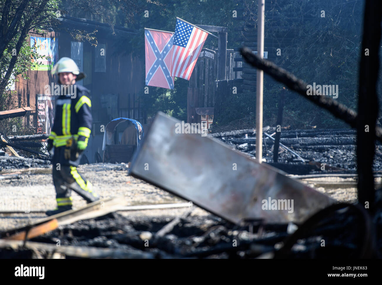 Dasing, Germany. 30th July, 2017. A firefighter walks past a burnt-down ...