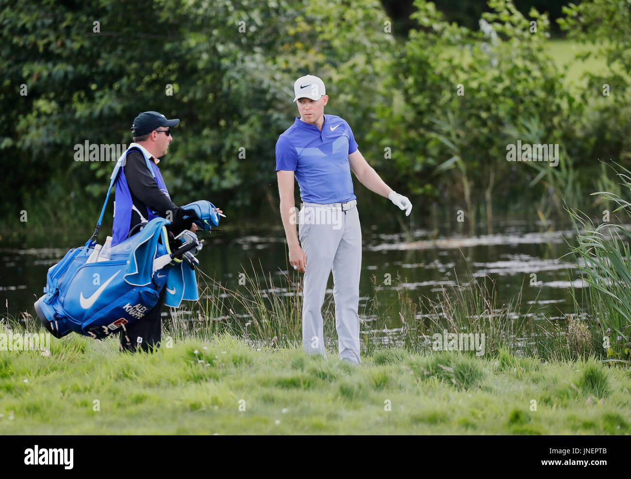 Alexander Knappe of Germany and his caddy discuss the ball which has ...