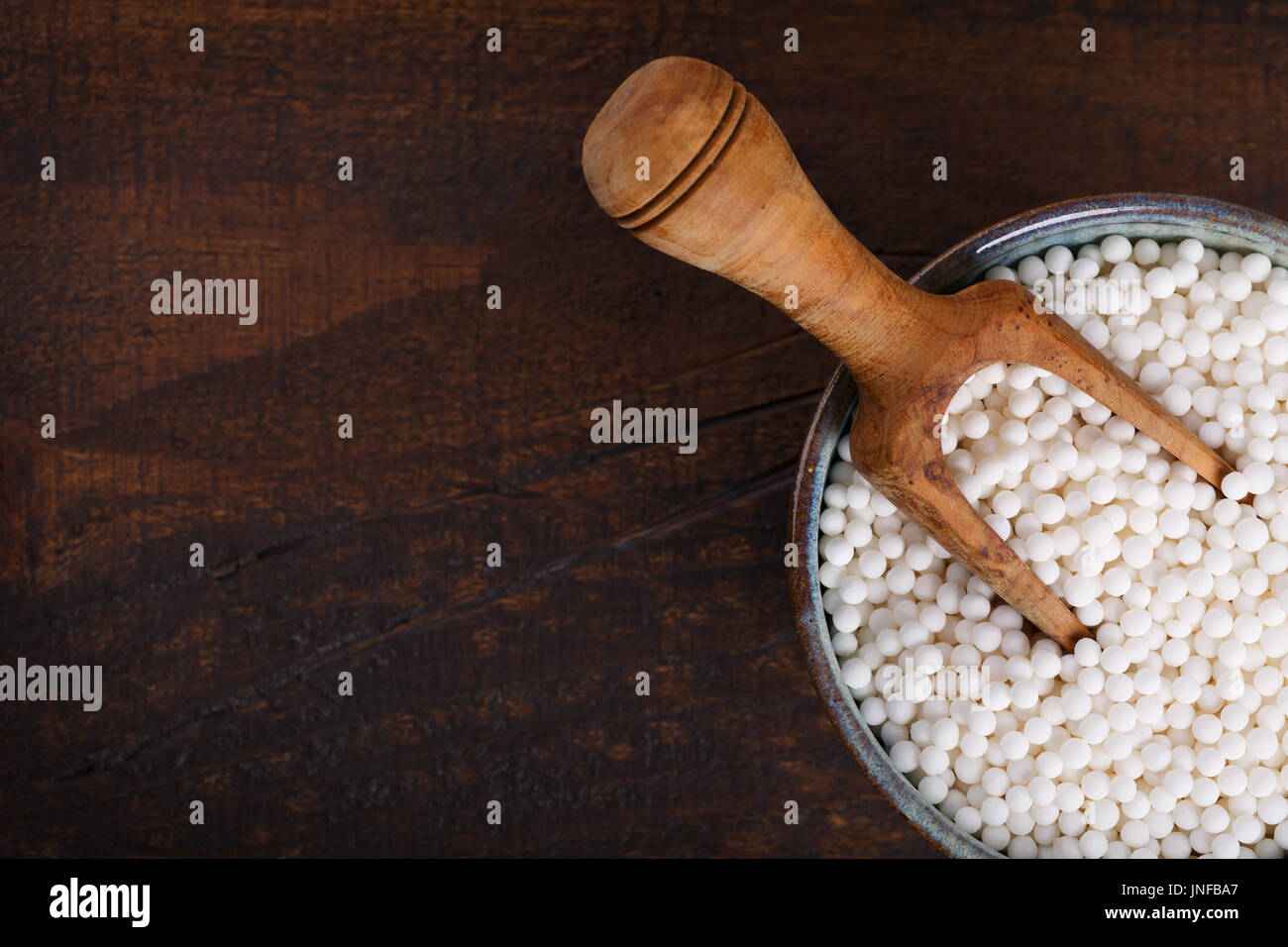 Granulated cassava (tapioca) on wooden background. Selective focus.Copy ...
