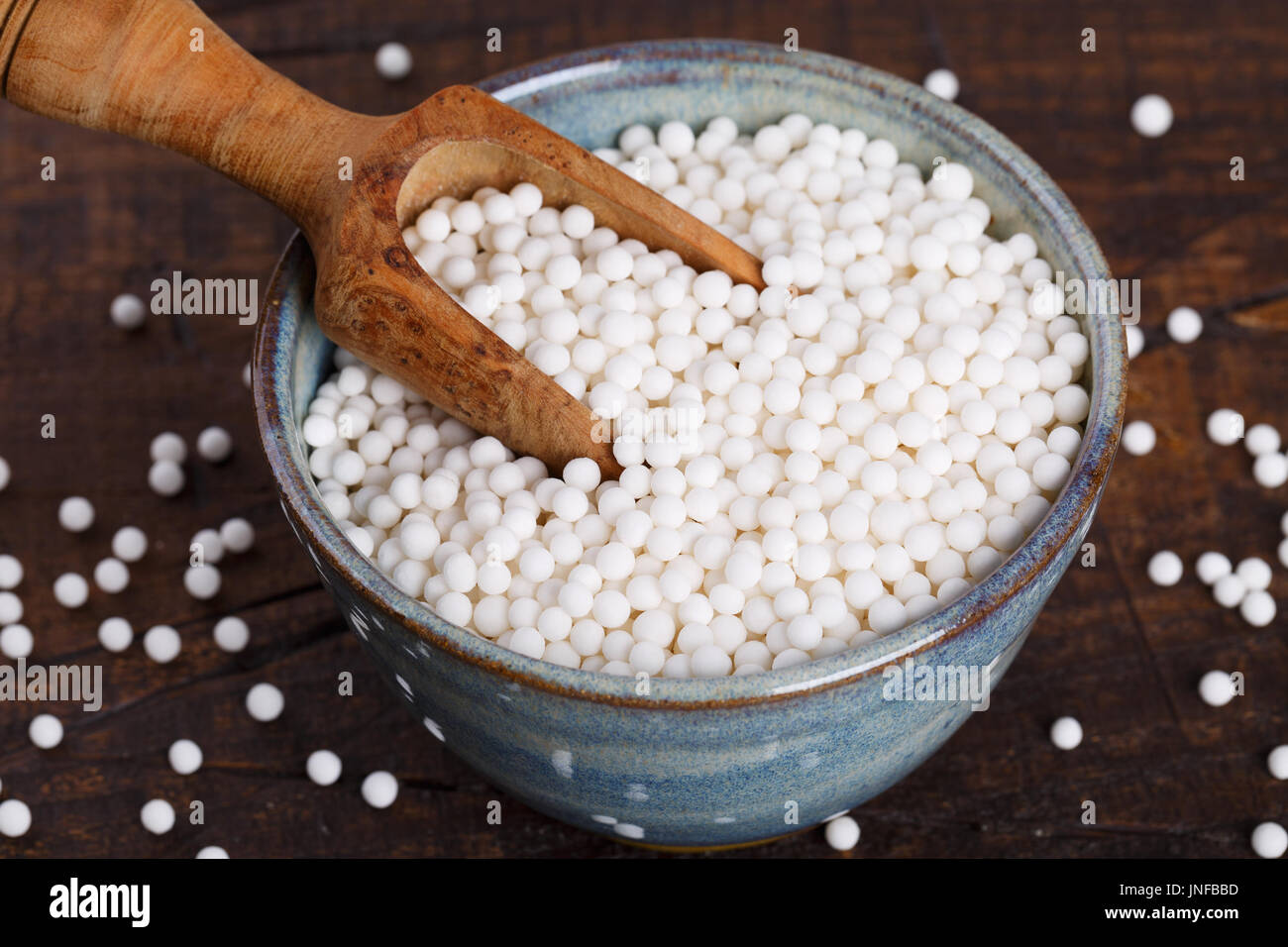 Granulated cassava (tapioca) on wooden background. Selective focus ...