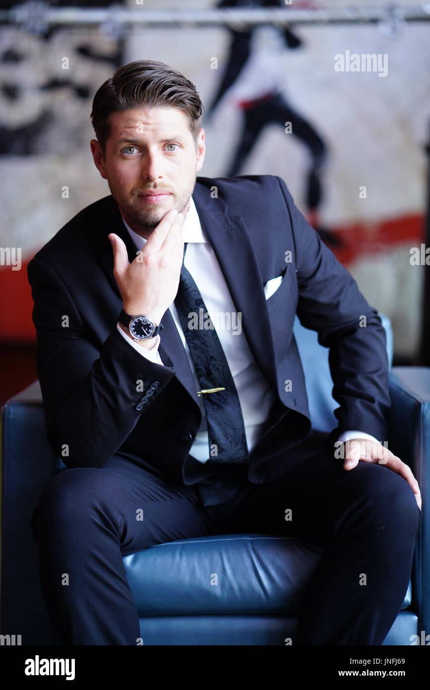 Young man sitting suit hi-res stock photography and images - Alamy