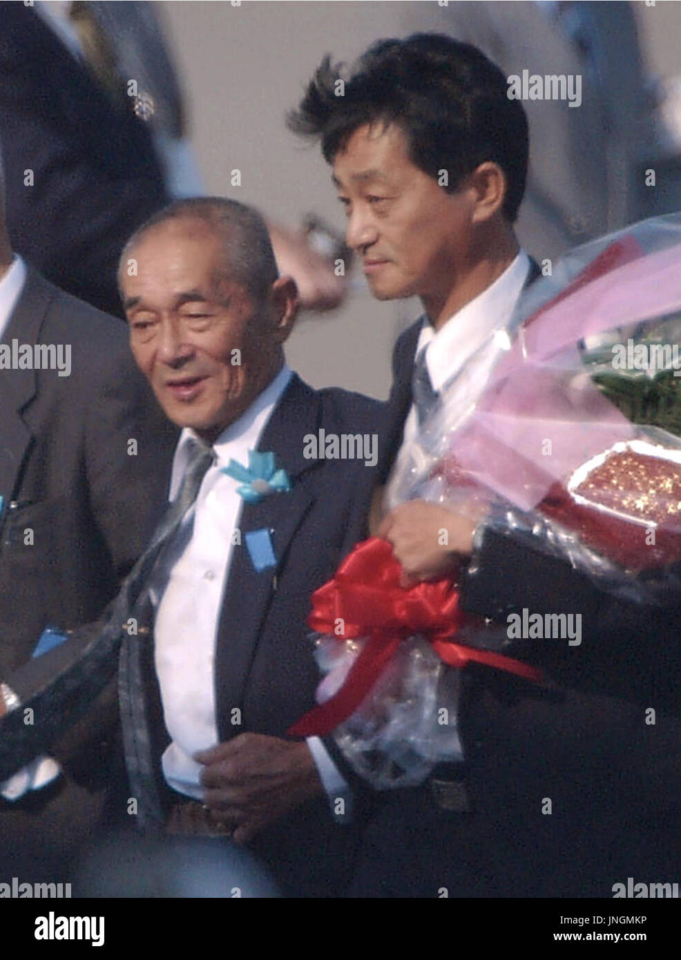 TOKYO, Japan - Yasushi Chimura (R) and his father Tamotsu join hands at ...