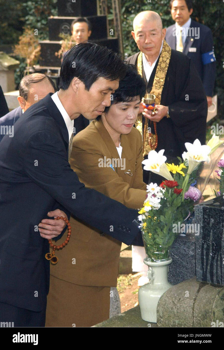 KASHIWAZAKI, Japan - Kaoru Hasuike (L) and his wife Yukiko Okudo lay flowers at the grave of ...