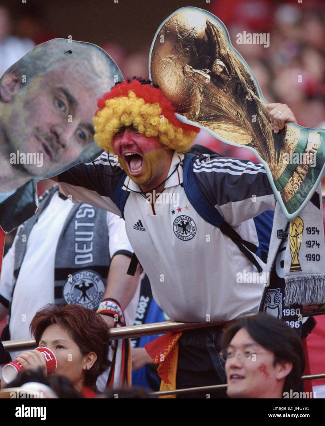 SEOUL, South Korea - A Germany supporter holds up cut-outs of coach ...