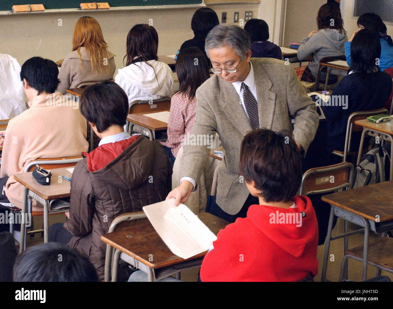 TOKYO, Japan - High-school students receive test papers from a teacher ...