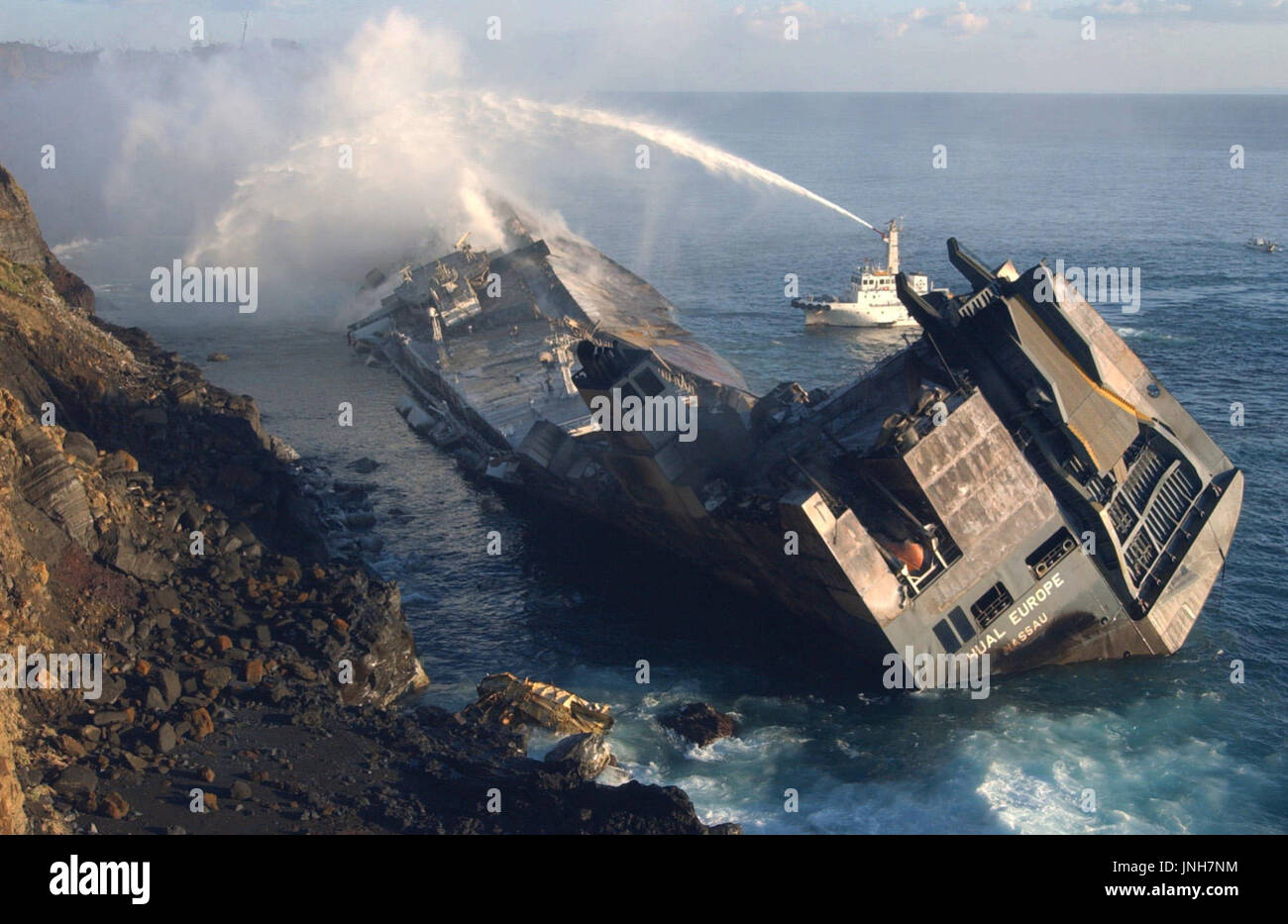 OSHIMA, Japan - A Japan Coast Guard ship directs water at the still ...