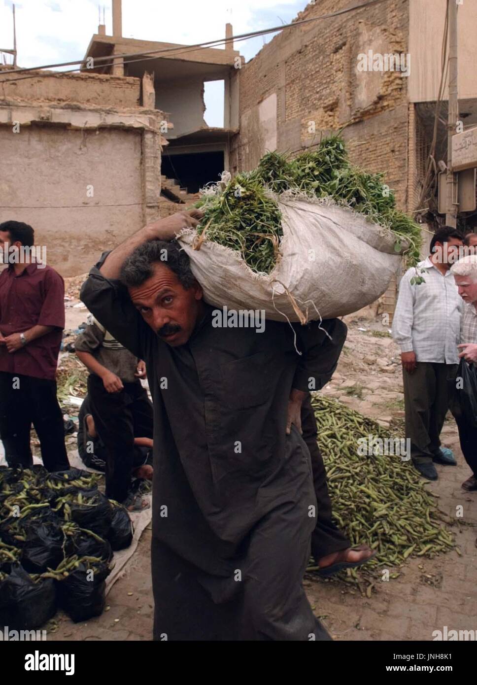 BAGHDAD, Iraq - An Iraqi man carries foodstuffs at a market in Baghdad ...