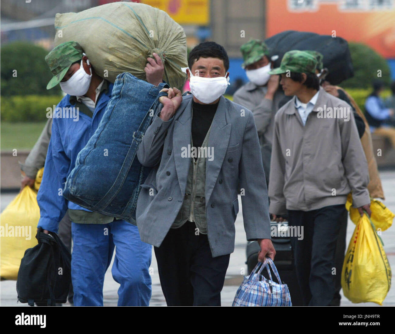 BEIJING, China - Workers wearing face masks amid the SARS epidemic walk ...