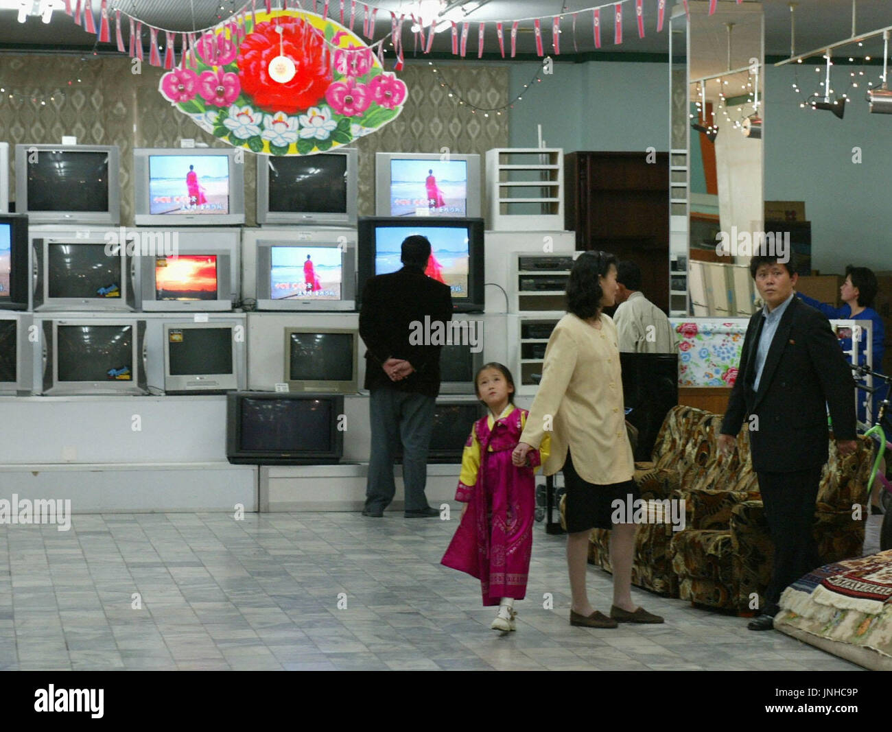 TOKYO, Japan - Shoppers inspect TV fs on sale at Pyongyang department ...