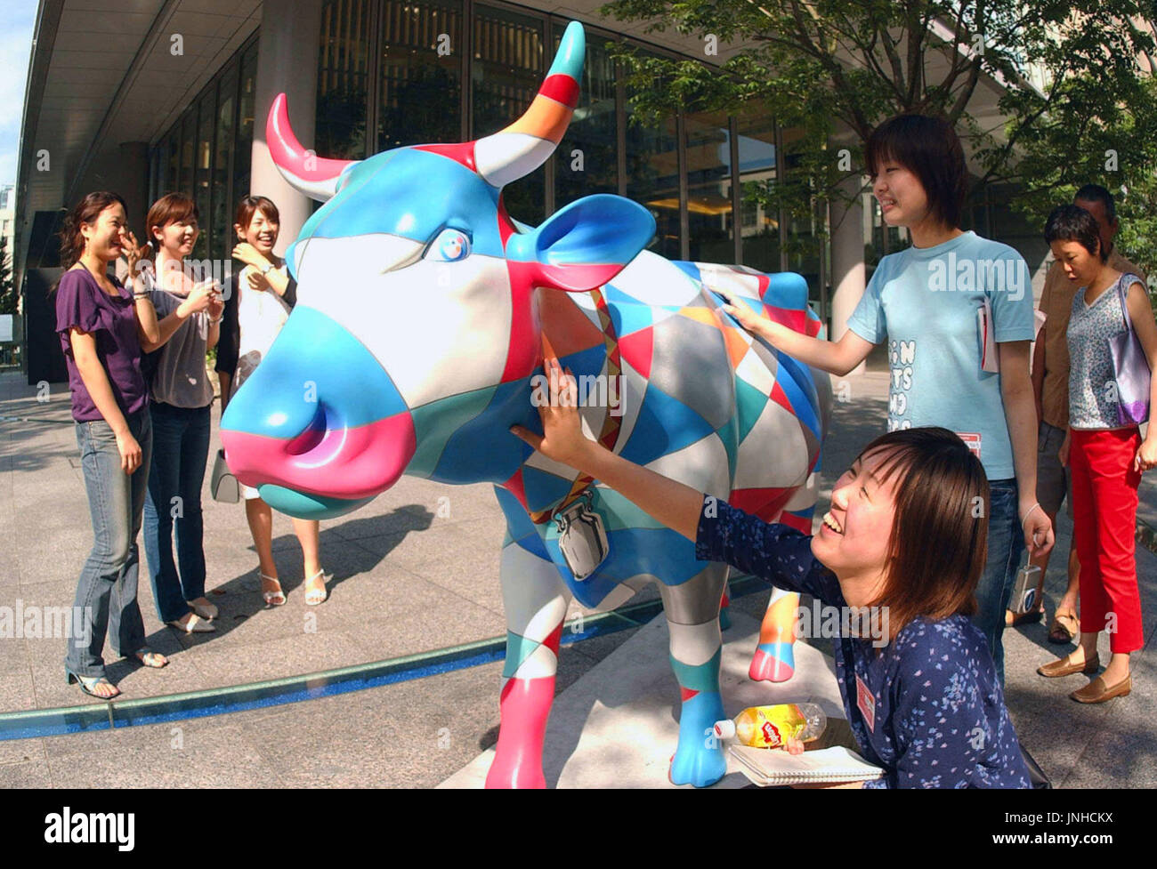 TOKYO, Japan - People look at a life-size cow sculpture, one of the 64 ...
