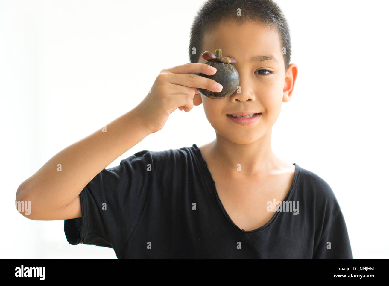 Asian boy shutting eyes with mangosteen isolated on white background ...