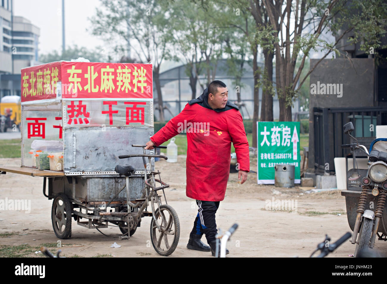 Chinese salesman is carrying his portable electric tricycle food ...