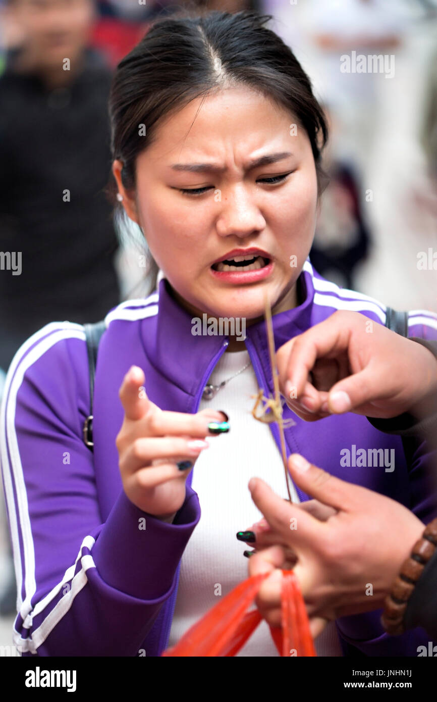 Chinese girl in sport gear on Wangfujing Market, Beijing, China trying ...